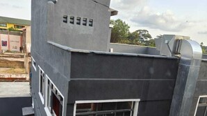 Um edifício moderno com teto plano, grandes janelas e antena parabólica visível.