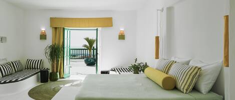 Quarto moderno com cama, área de estar e varanda.