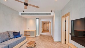 Uma sala de estar moderna com um sofá, uma mesa de centro e uma televisão.