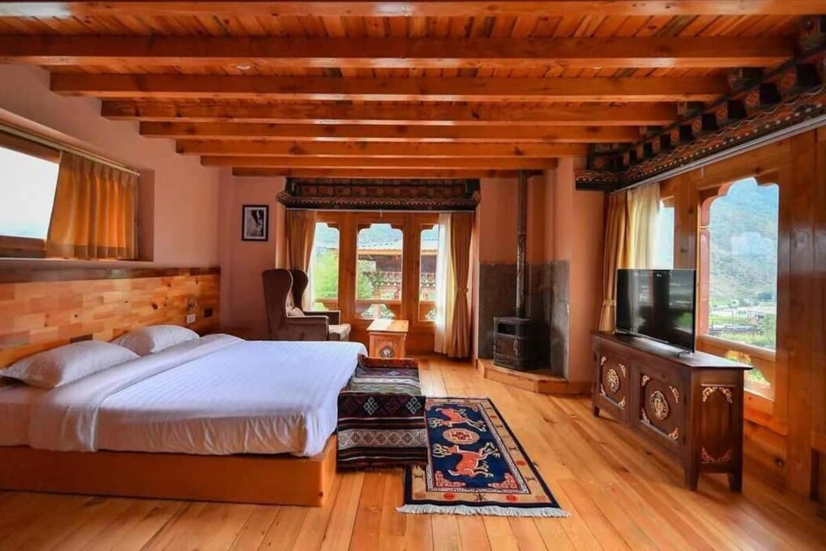 Quarto de madeira com uma cama, televisão e lareira.