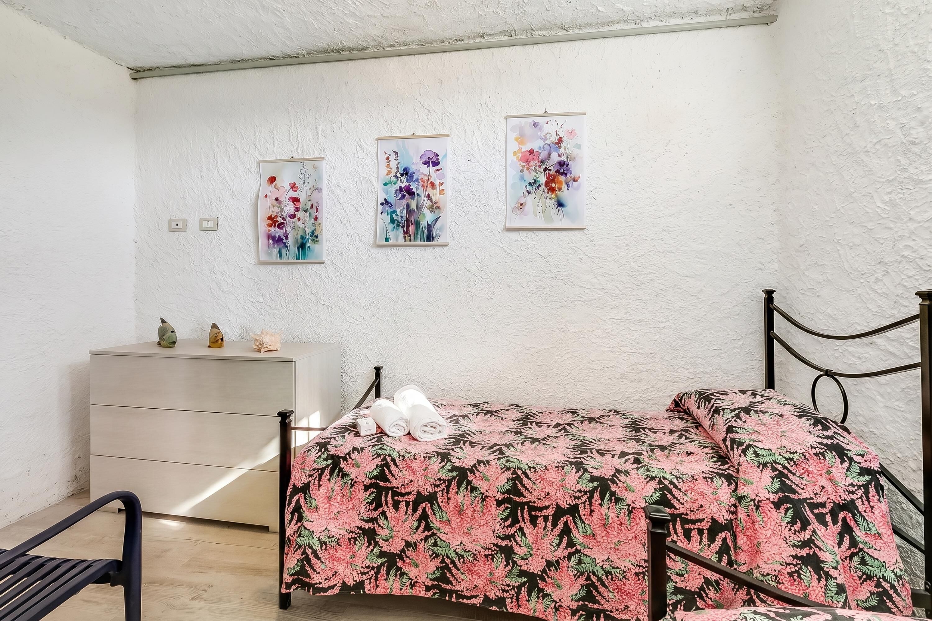 Quarto com cama, cómoda e arte nas paredes.