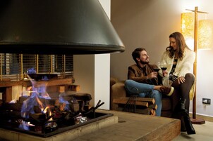 Uma sala de estar aconchegante com lareira, um sofá e uma luminária.
