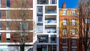 Um edifício moderno com vários andares, janelas amplas e varandas.