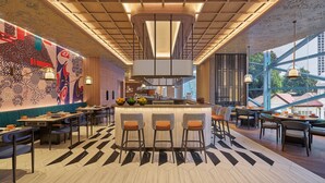 Um restaurante moderno com um bar central, tetos altos e piso estampado.