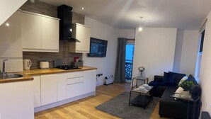 Um apartamento moderno com cozinha, sala de estar e varanda.