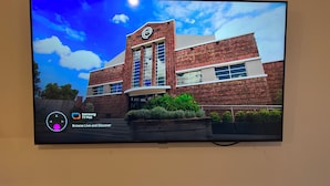 Um edifício moderno com fachada de tijolos, grandes janelas e um logotipo bem visível no topo.