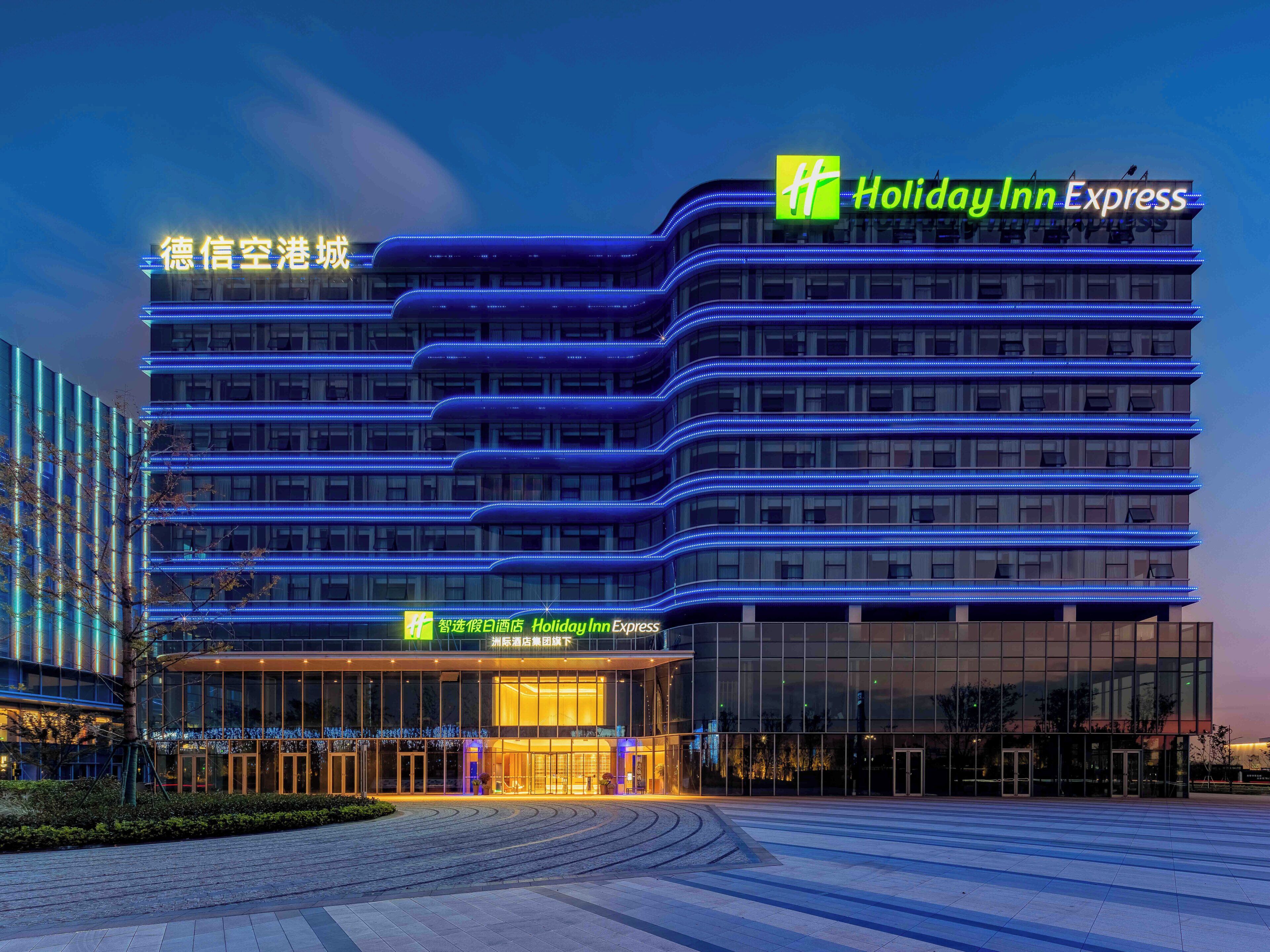 Um hotel Holiday Inn Express de vários andares, com design moderno e sinalização iluminada.