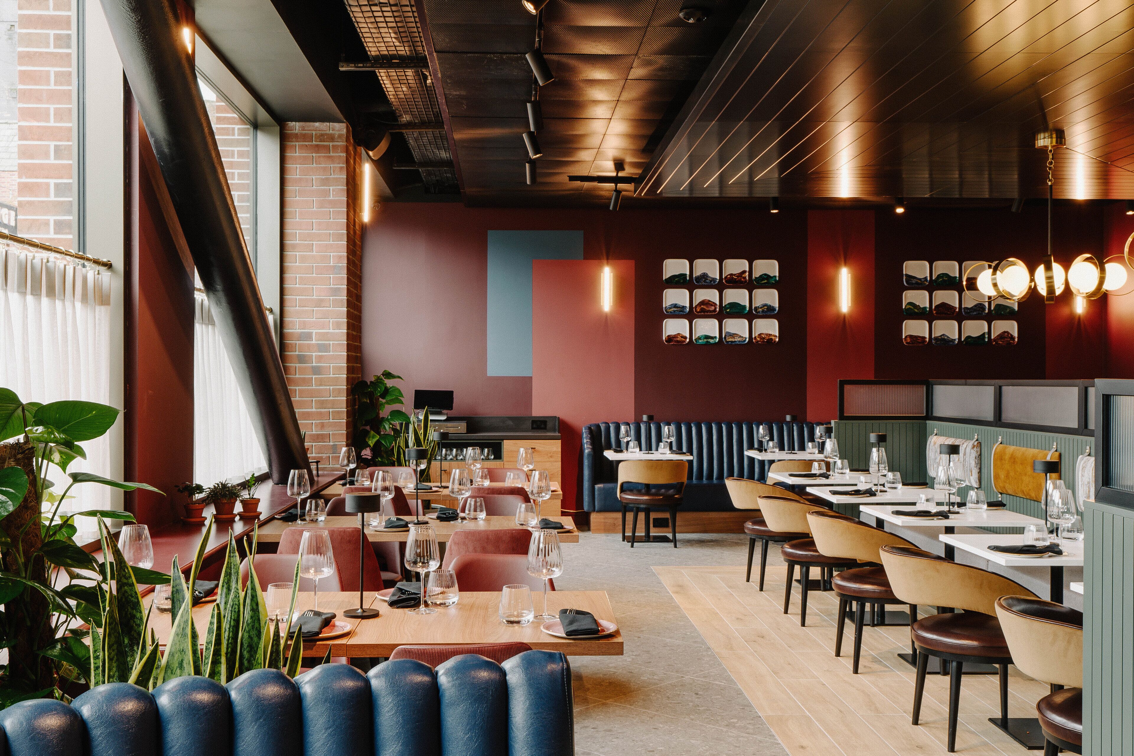 Um restaurante com um balcão extenso, cabines e uma parede de tijolos.