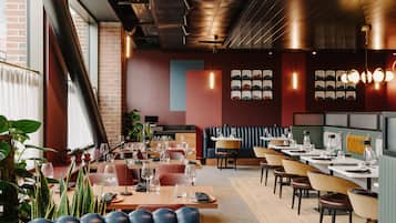 Um restaurante com um balcão extenso, cabines e uma parede de tijolos.