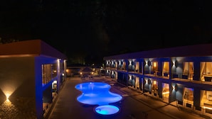 Um hotel com piscina e vários quartos de hóspedes.