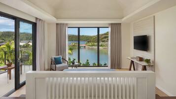 Quarto moderno com vista para um lago, televisão e área de estar também com vista.