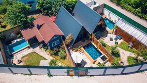 Um imóvel residencial com piscina, quintal cercado e garagem separada.