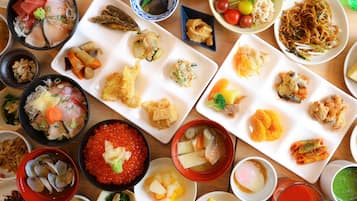 Diversos pratos dispostos sobre uma mesa de madeira, incluindo sashimi, tempura e outras especialidades da culinária japonesa.