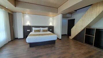 Um quarto moderno com uma cama grande, piso de madeira e uma escada.