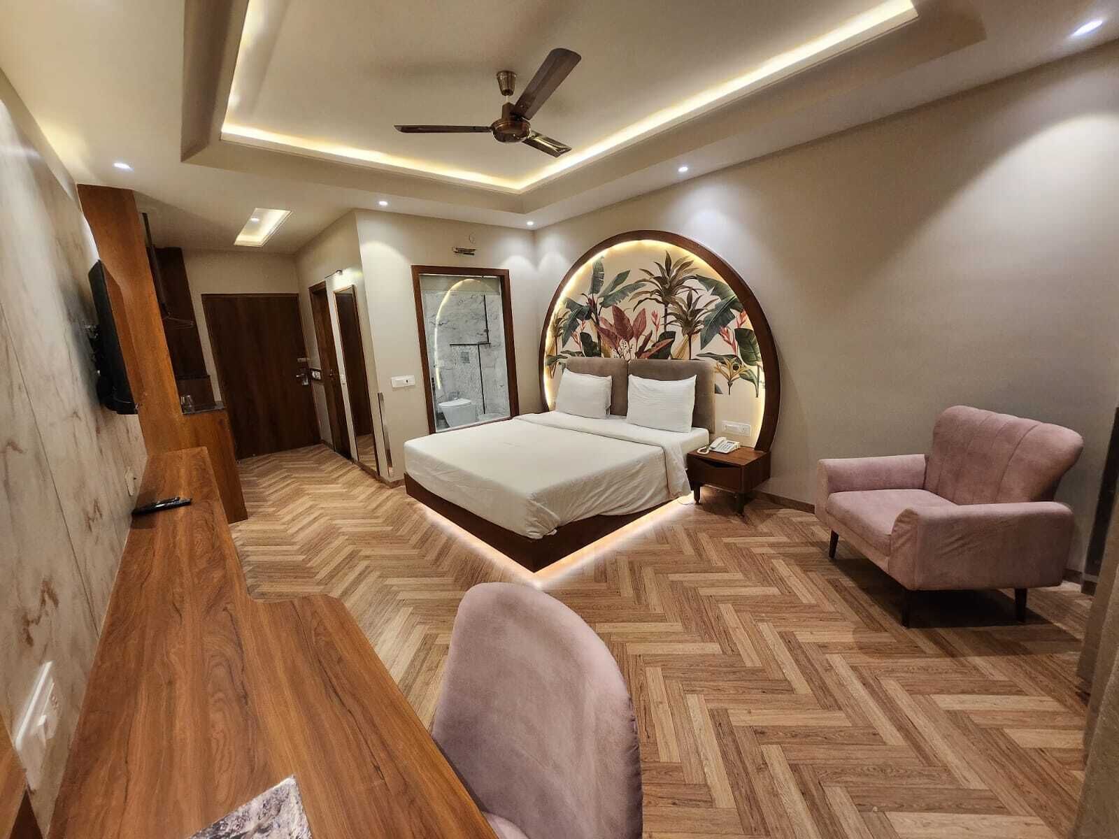 Quarto moderno com cama, uma cadeira, escrivaninha e ventilador de teto.