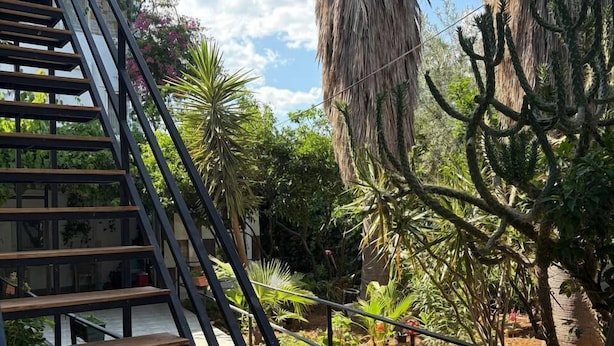 Uma escadaria com guarda-corpo de metal que leva a um edifício.