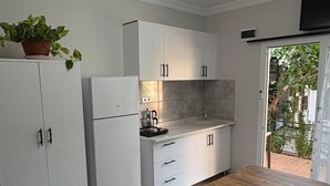 Uma cozinha moderna com armários brancos, forno embutido e uma mesa de jantar de madeira.