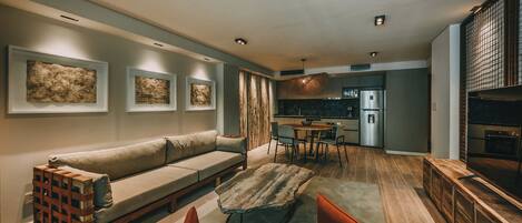 Uma sala de estar moderna com um sofá, uma mesa de centro e um espaço de jantar com cadeiras.