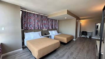 Quarto de hotel com duas camas, um espelho grande, uma escrivaninha e uma cadeira.