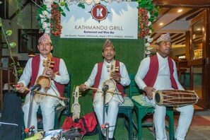 Três músicos se apresentando no Restaurante e Bar de Vinhos Kathmandu Grill.