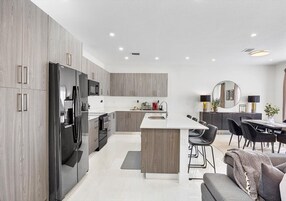 Um micro-ondas, uma placa de cozinha, uma cafeteira/bule 