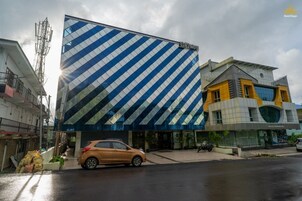 Um edifício moderno com fachada azul e branca quadriculada, um letreiro chamativo com a inscrição 