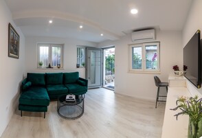 Apartamento luxo | Área de estar | TV de tela plana 82 cm com canais via satélite