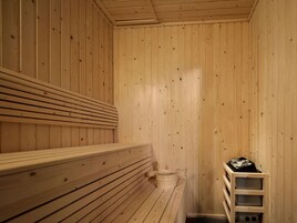 Uma sauna de madeira com bancos e um pequeno armário.