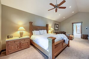 Quarto espaçoso com uma cama grande, um ventilador de teto e vista para o exterior.