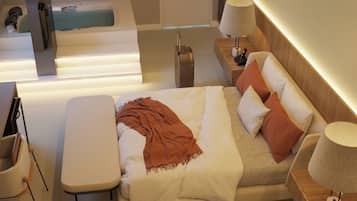Quarto de hotel moderno com uma cama grande, uma mesa pequena, um banco, uma banheira e uma mesa de cabeceira com abajur.