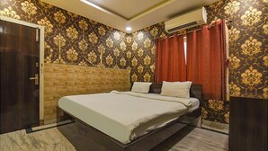 Quarto com cama, cabeceira, guarda-roupa e aparelho de ar condicionado.
