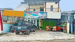Um edifício com uma placa que diz "HOME STAY Surya JLN SEROJA 2".