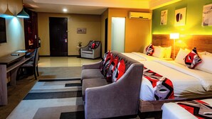 Quarto de hotel com cama, sofá, escrivaninha e cadeira.