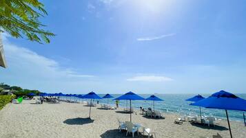 Na praia, espreguiçadeiras, guarda-sóis
