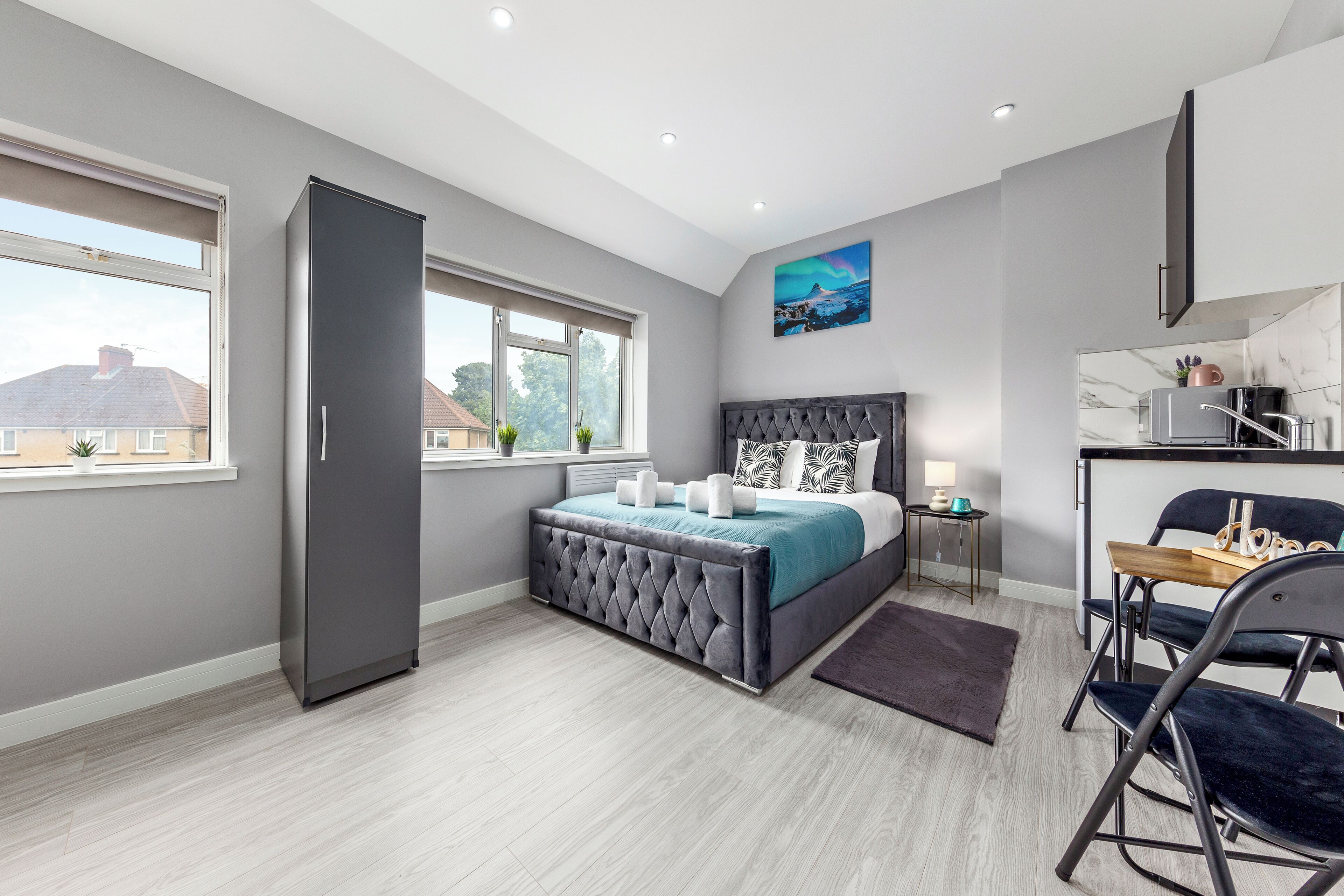 Quarto moderno com uma cama grande, uma escrivaninha e vista para o exterior.