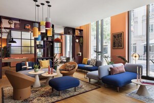 Uma sala de estar moderna com sofás azuis, mesa de bilhar e estante de livros.