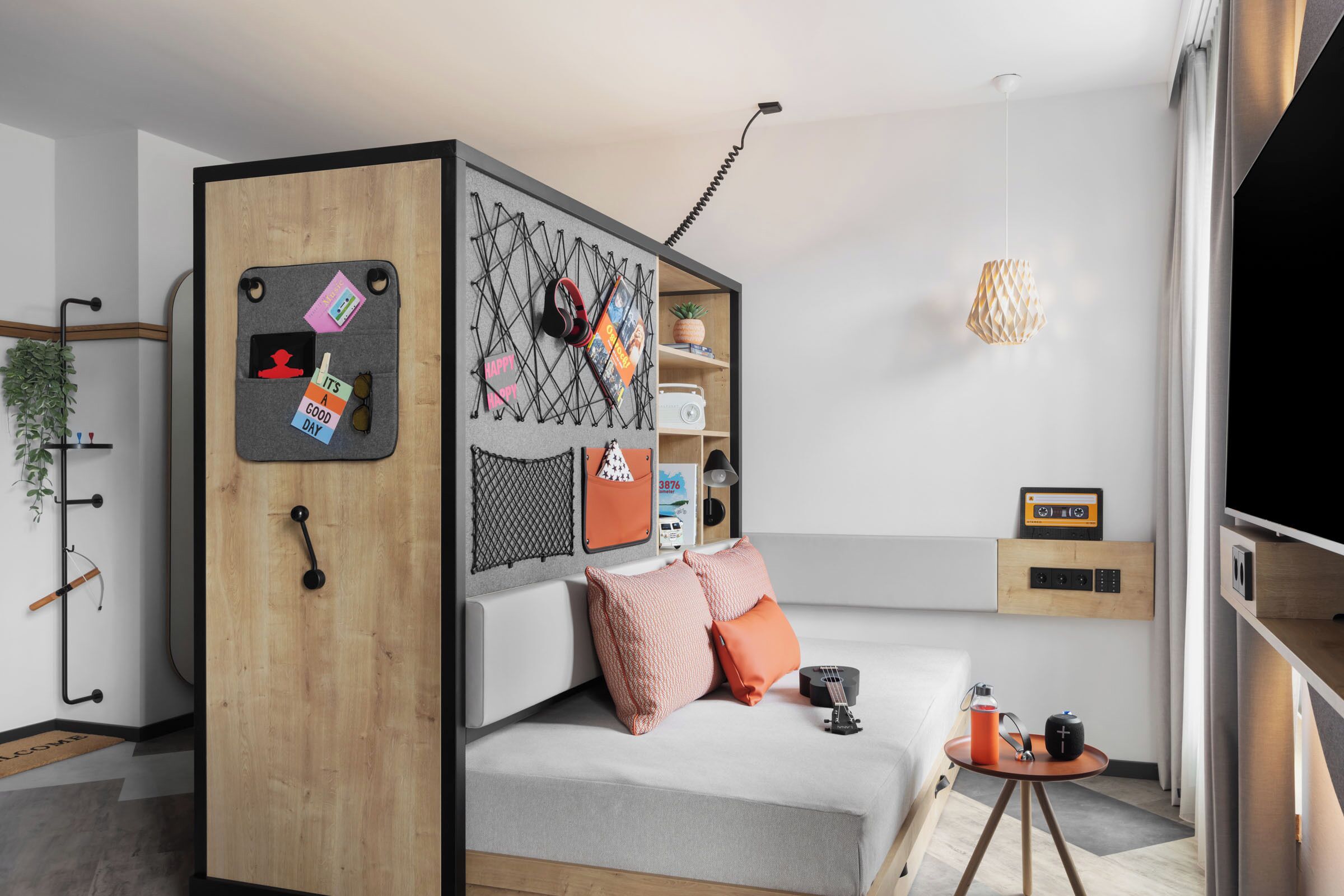 Quarto moderno com cama, mesa de apoio, prateleira na parede e luminária suspensa.
