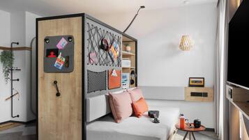 Quarto moderno com cama, mesa de apoio, prateleira na parede e luminária suspensa.