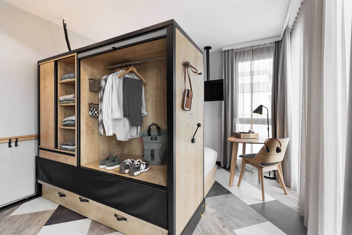 Quarto moderno com roupeiro embutido, uma escrivaninha e uma cadeira.