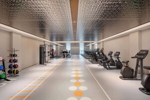Uma academia com esteiras, elípticos e uma bicicleta ergométrica.