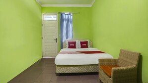 Um quarto com uma cama, uma cadeira e uma porta.