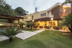 Uma casa moderna com um pátio, área de estar externa e piscina.