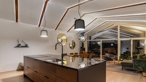 Uma cozinha moderna com ilha central, armários de madeira e iluminação pendente.
