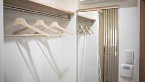 Um armário com cabides de madeira e um espelho.