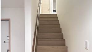 Escada com corrimão levando a uma porta no topo.
