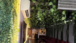 Um interior moderno com parede verde, assentos vermelhos e unidade de ar condicionado branca.