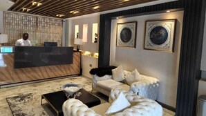 Um hall de hotel moderno com uma mesa de recepção, assentos confortáveis e obras de arte nas paredes.