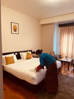 Quarto de hotel com cama, escrivaninha e cadeira.