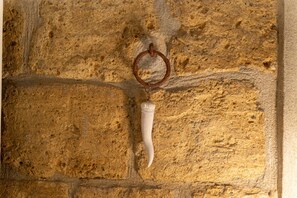 Parede de pedra com um aro de metal e um objeto branco pendurado.