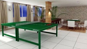 Uma mesa de bilhar em um quarto moderno com parede estampada, área de refeições e uma coluna alta.